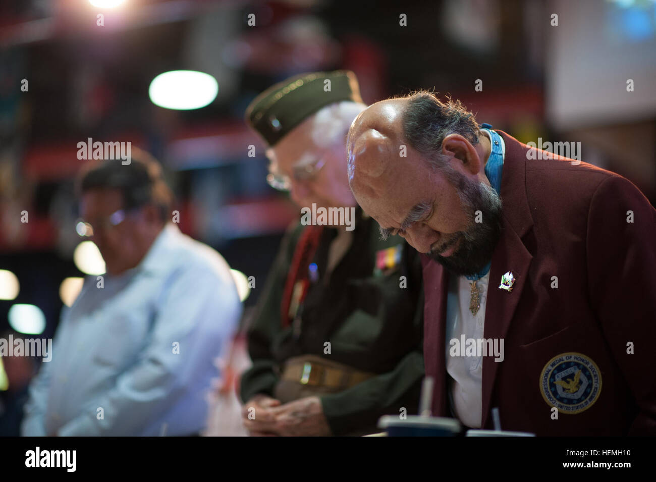 Medal of Honor recipient Rudy Hernandez, right, bows his head in prayer ...
