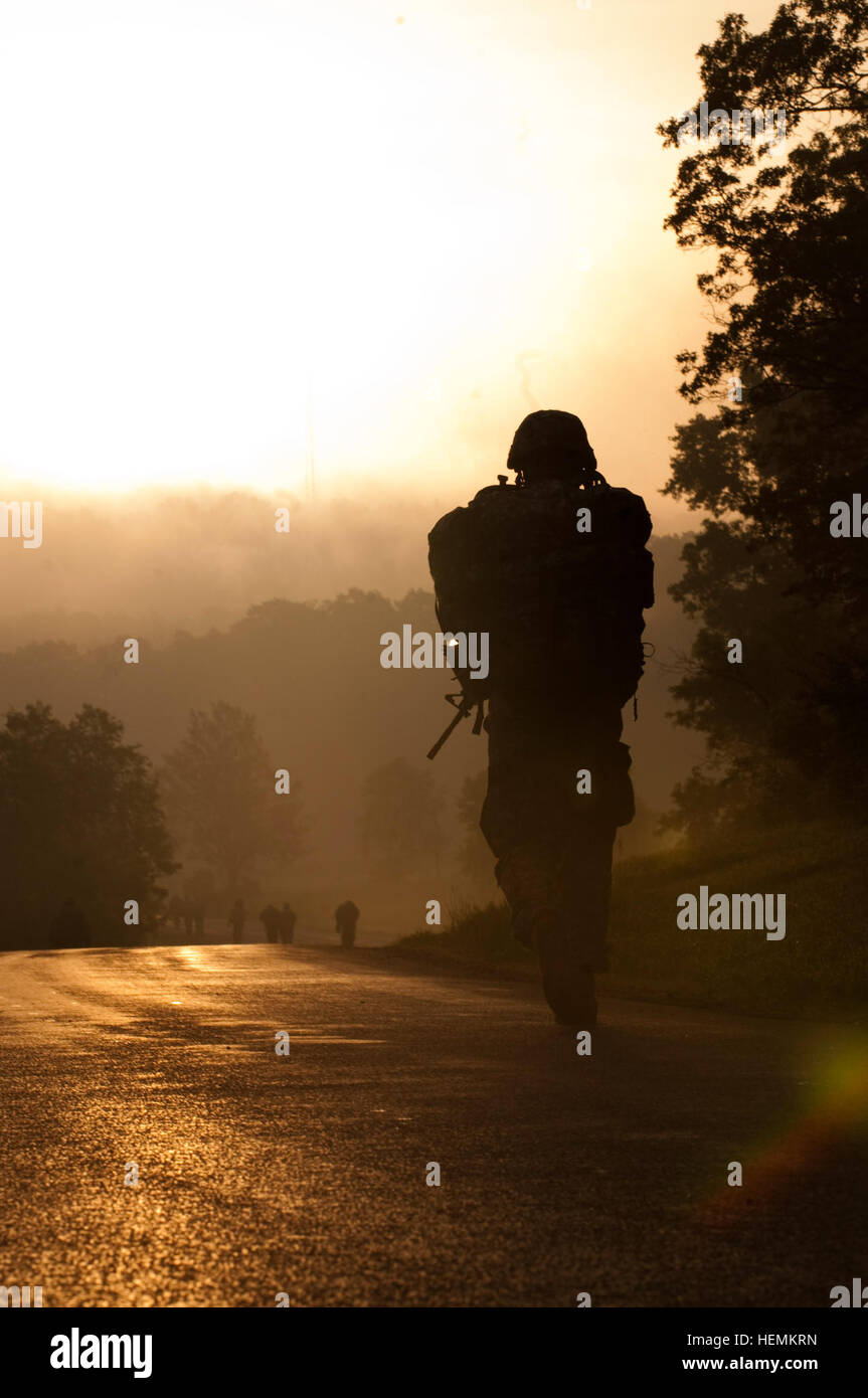 A U.S. soldier walk along at a quick pace into the rising sun during ...