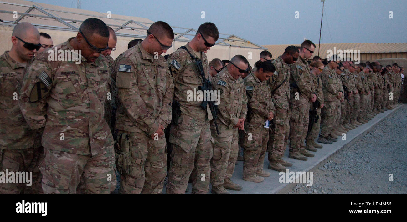 Civilian contractors and service members stand and pray to honor the ...