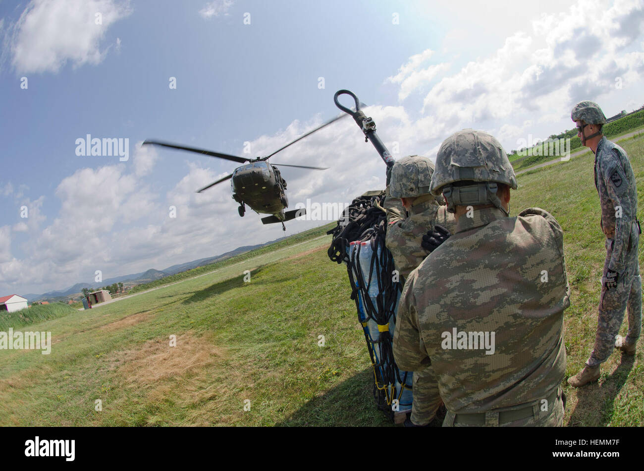 Turkish soldiers wait as a UH-60 Black Hawk helicopter approaches ...