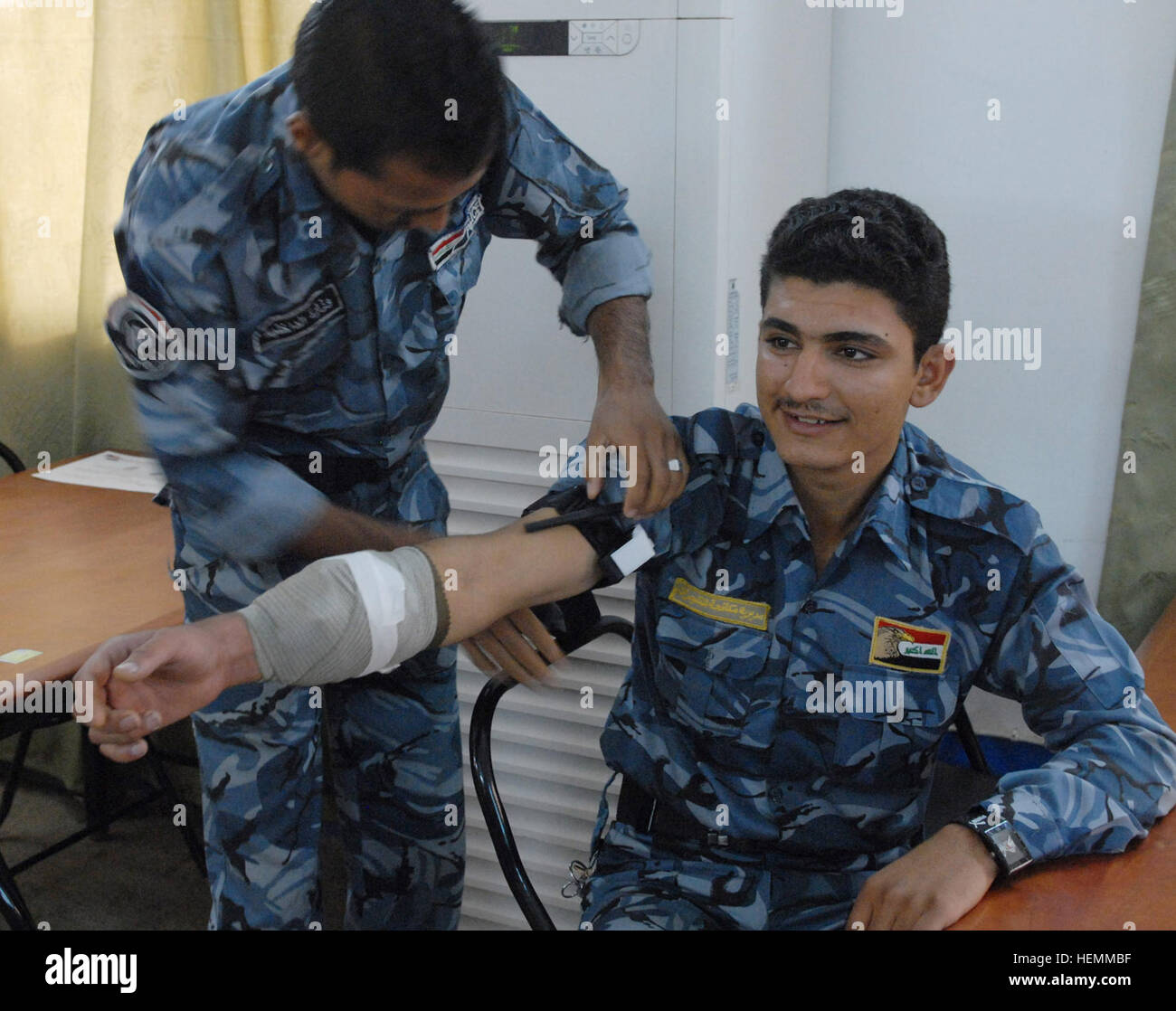 Iraqi Police officers practice applying a tourniquet during a first aid ...