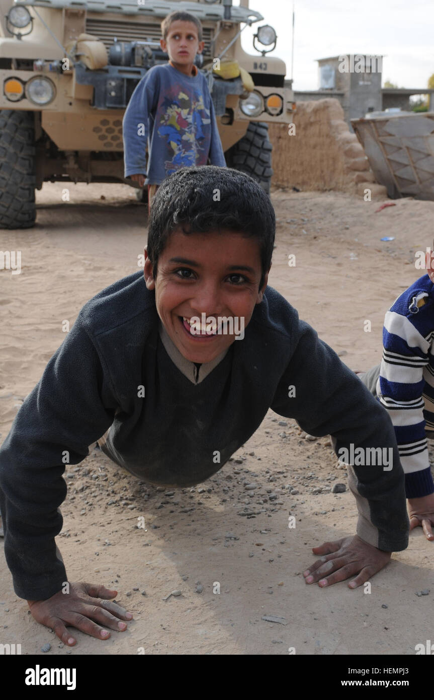 An Iraqi boy from Butoma, Iraq, demonstrates push-ups to Soldiers from ...