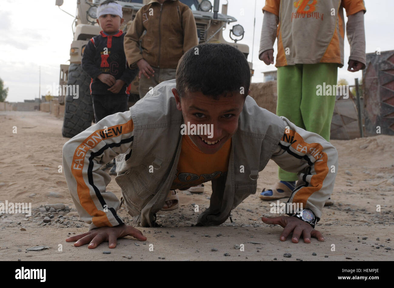 An Iraqi boy from Butoma, Iraq, demonstrates push-ups to Soldiers from ...