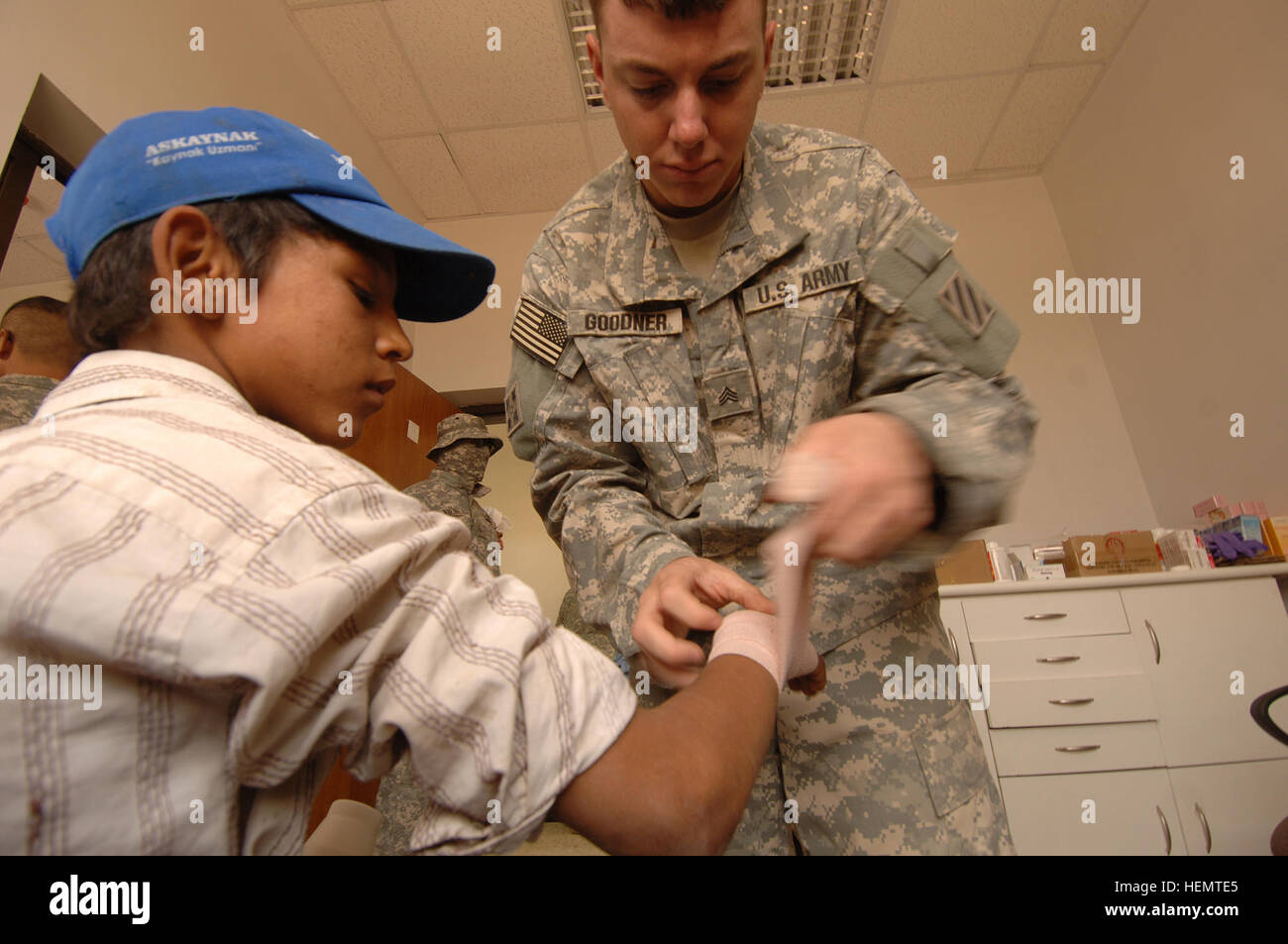 A young Iraqi boy has his sprained wrist wrapped by a U.S. Army Sgt ...