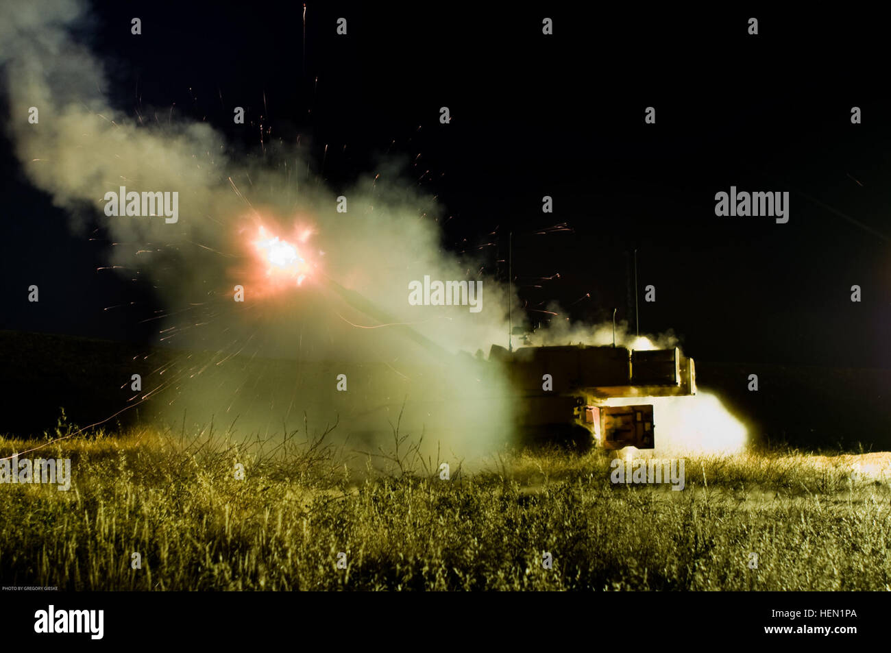 With a sudden flash of blinding light an M109A6 Paladin lights up the ...