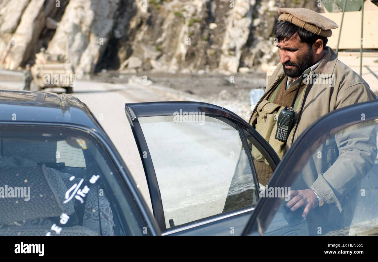An Afghan national policeman searches a vehicle during a 'snap ...