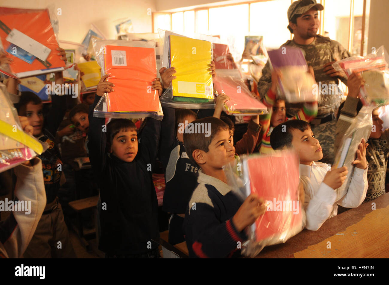 Children at the Al Waleed School hold up the school-supply kits ...