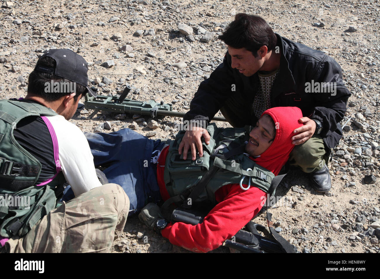 An Afghan Civilian Mine Removal Group member applies a tourniquet to ...