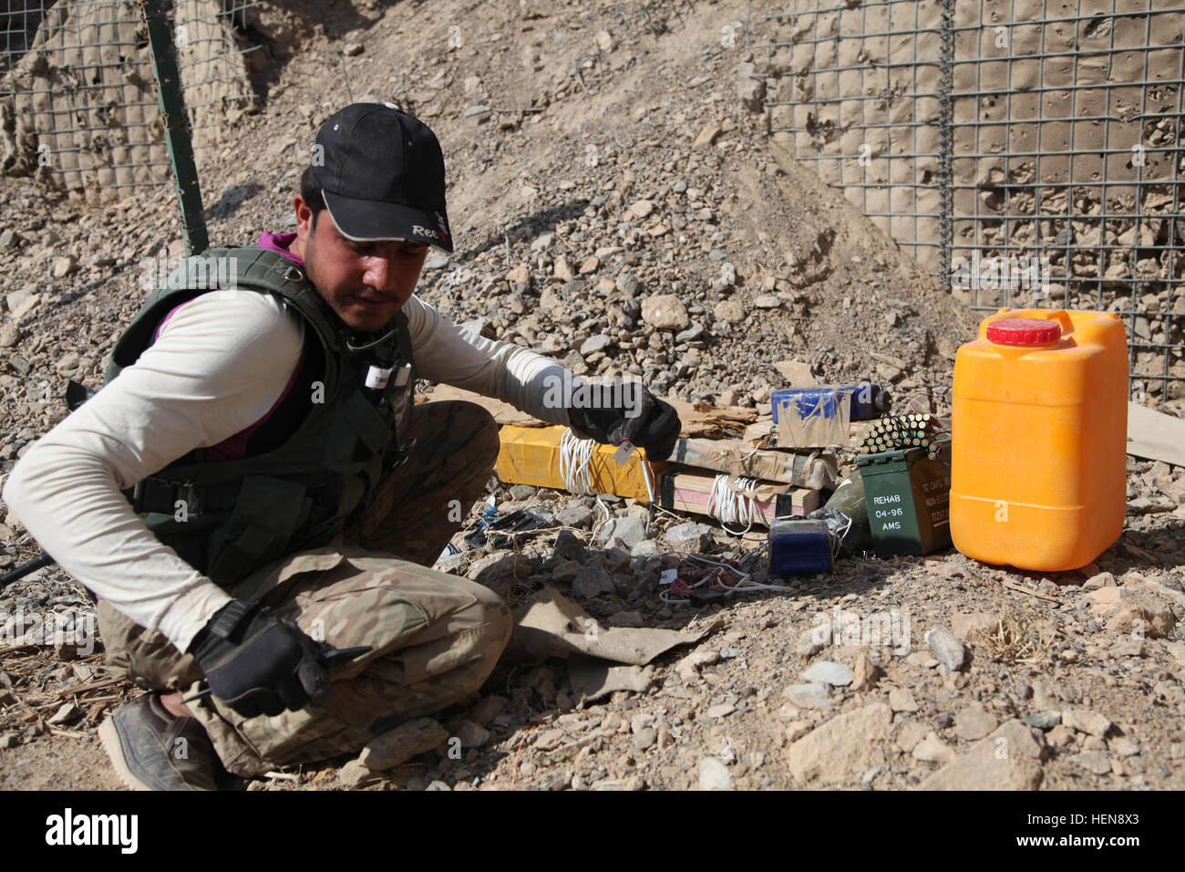 An Afghan Civilian Mine Removal Group member investigates a cache of ...