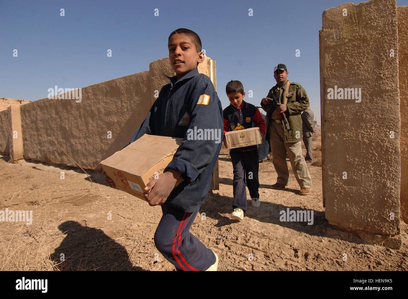 Two young Iraqi boys carry a boxes full of medical supplies provided by ...
