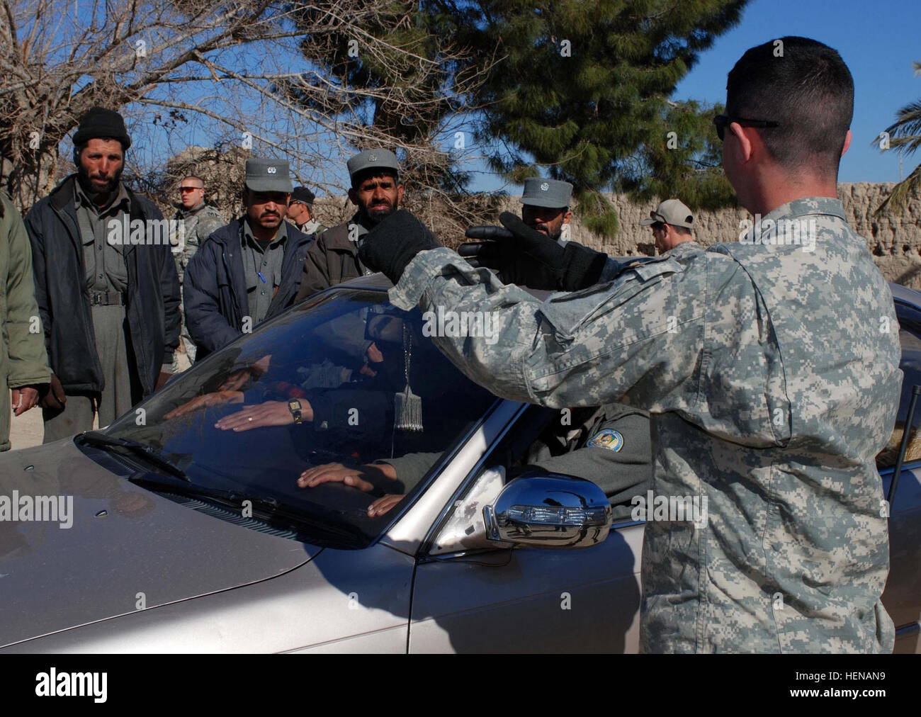 Policemen help simulate a hasty vehicle search while their fellow ...