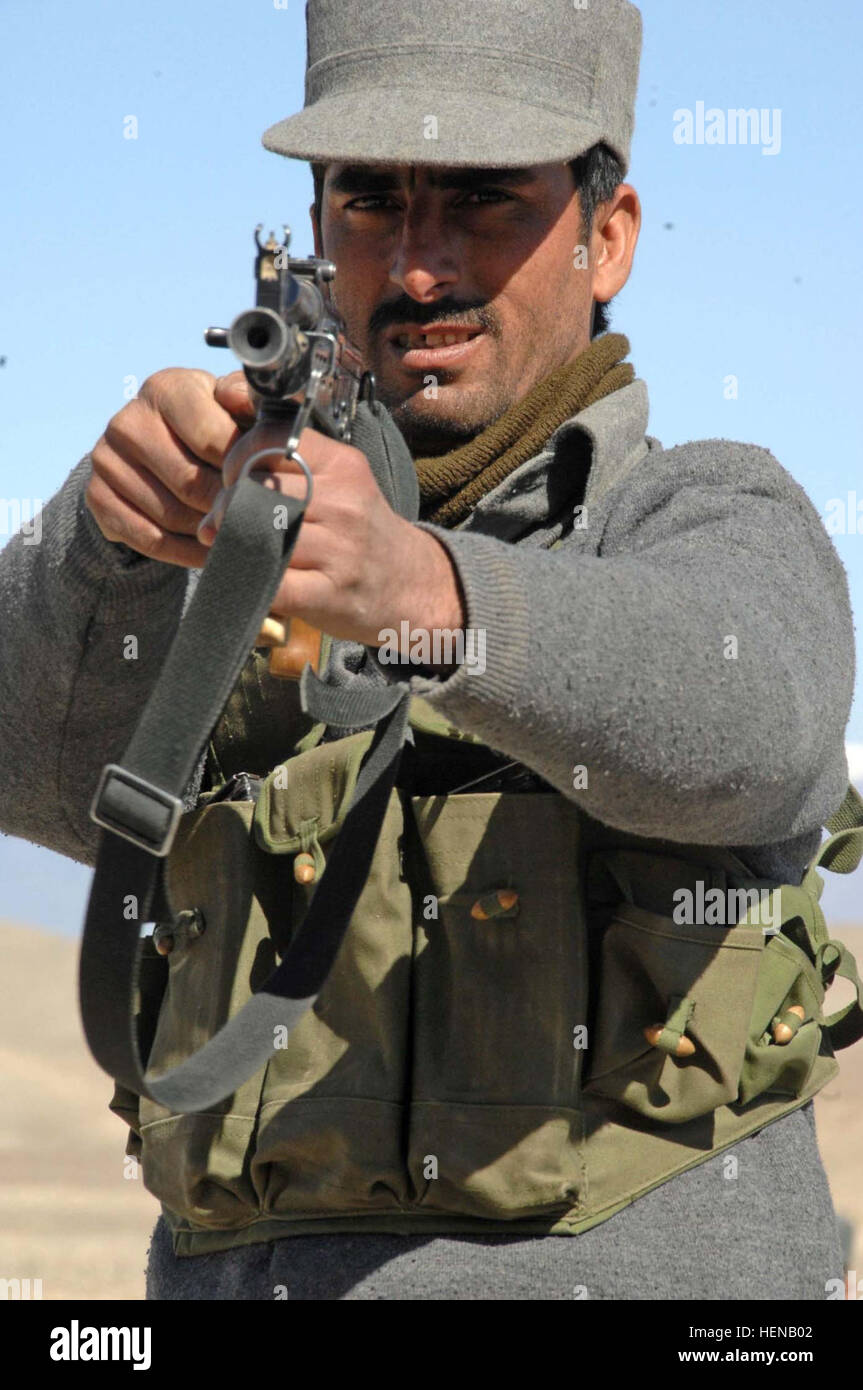 An Afghan national policeman practices reflexive fire at a range near ...