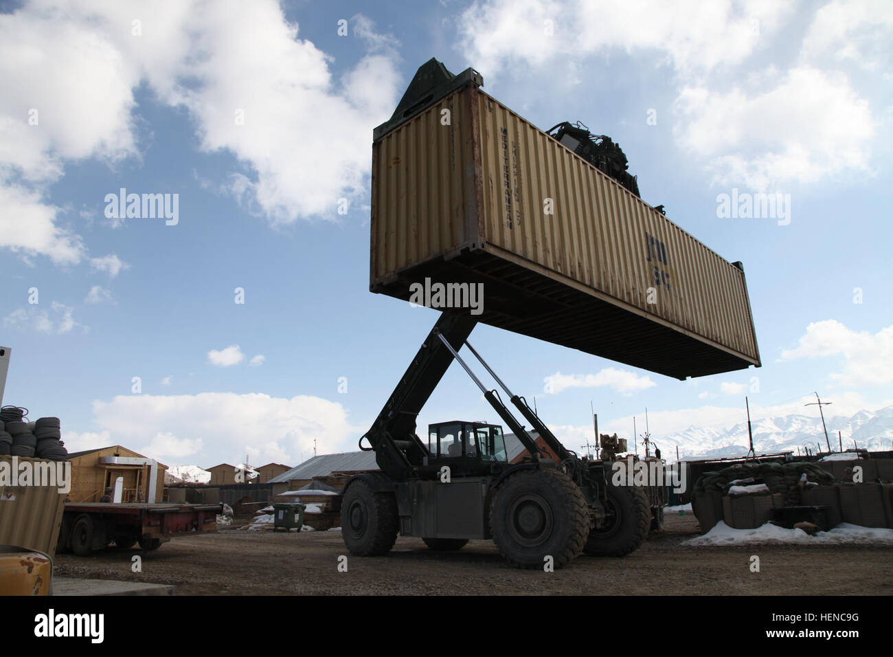 A U.S. Army RT240 rough terrain container handler carries a container ...