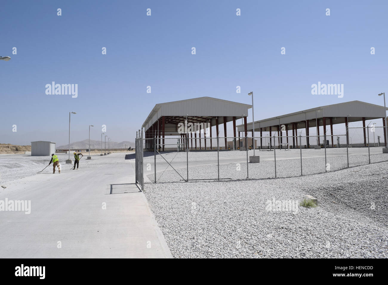 Afghan workers clear gravel from the driveway of the sorting compound ...