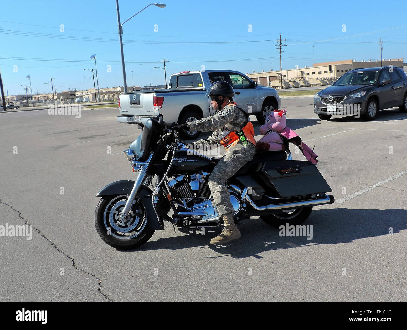 A soldier motorcycle rider rides off wearing the required PPE: over the ...