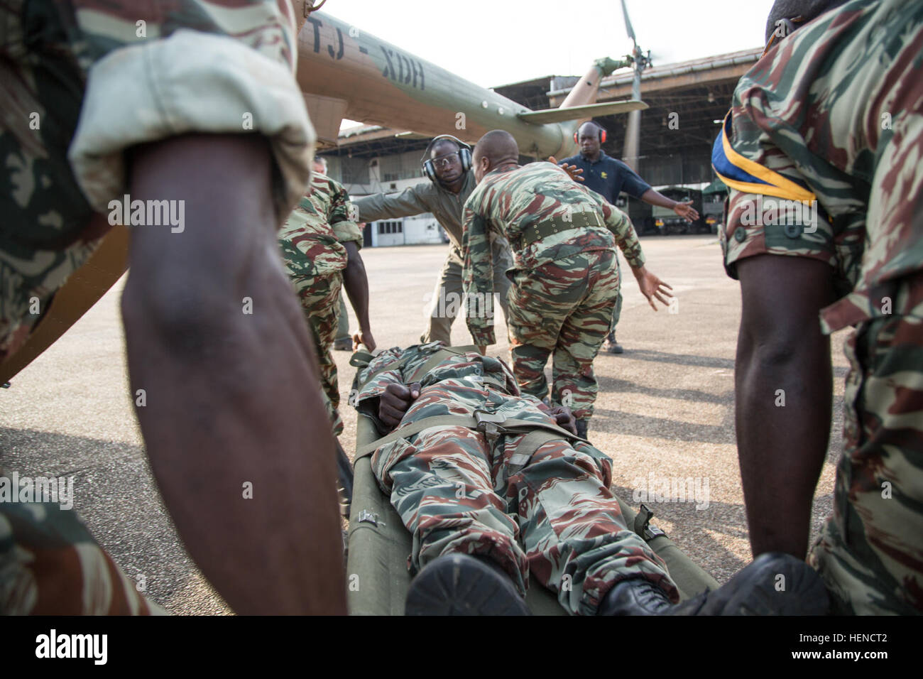 Cameroon military firefighters carry a simulated casualty to a ...