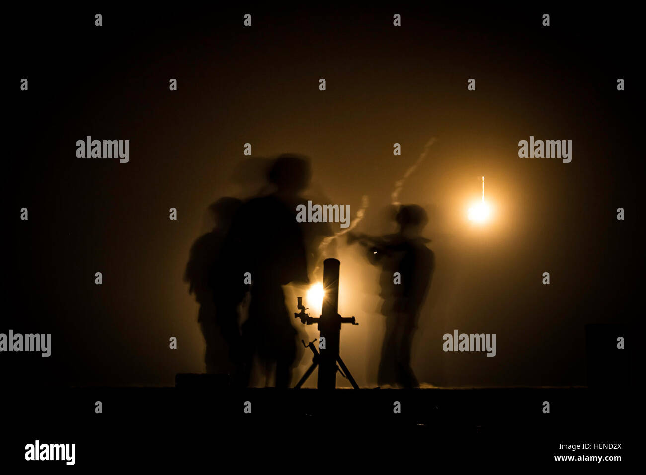 A 120mm mortar illumination rounds silhouette a mortar team ...