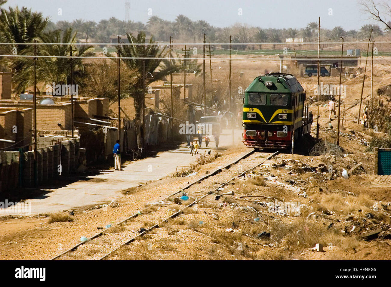 An Iraqi locomotive passes a crowd of villagers upon its approach to ...