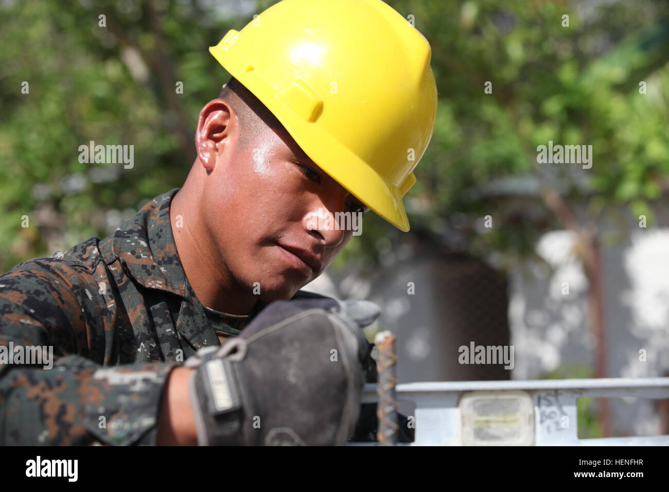 A Guatemalan soldier levels cinderblocks for a new clinic for the Las ...