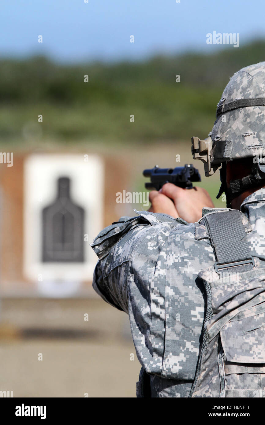 A Soldier fires a round at his target during M9 weapons qualification ...