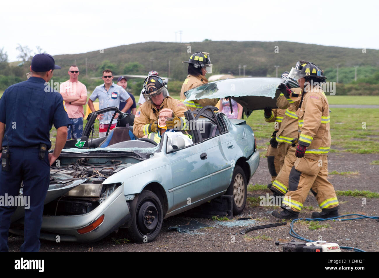 Three Honolulu Fire Department rescue workers use an axe and the Jaws ...