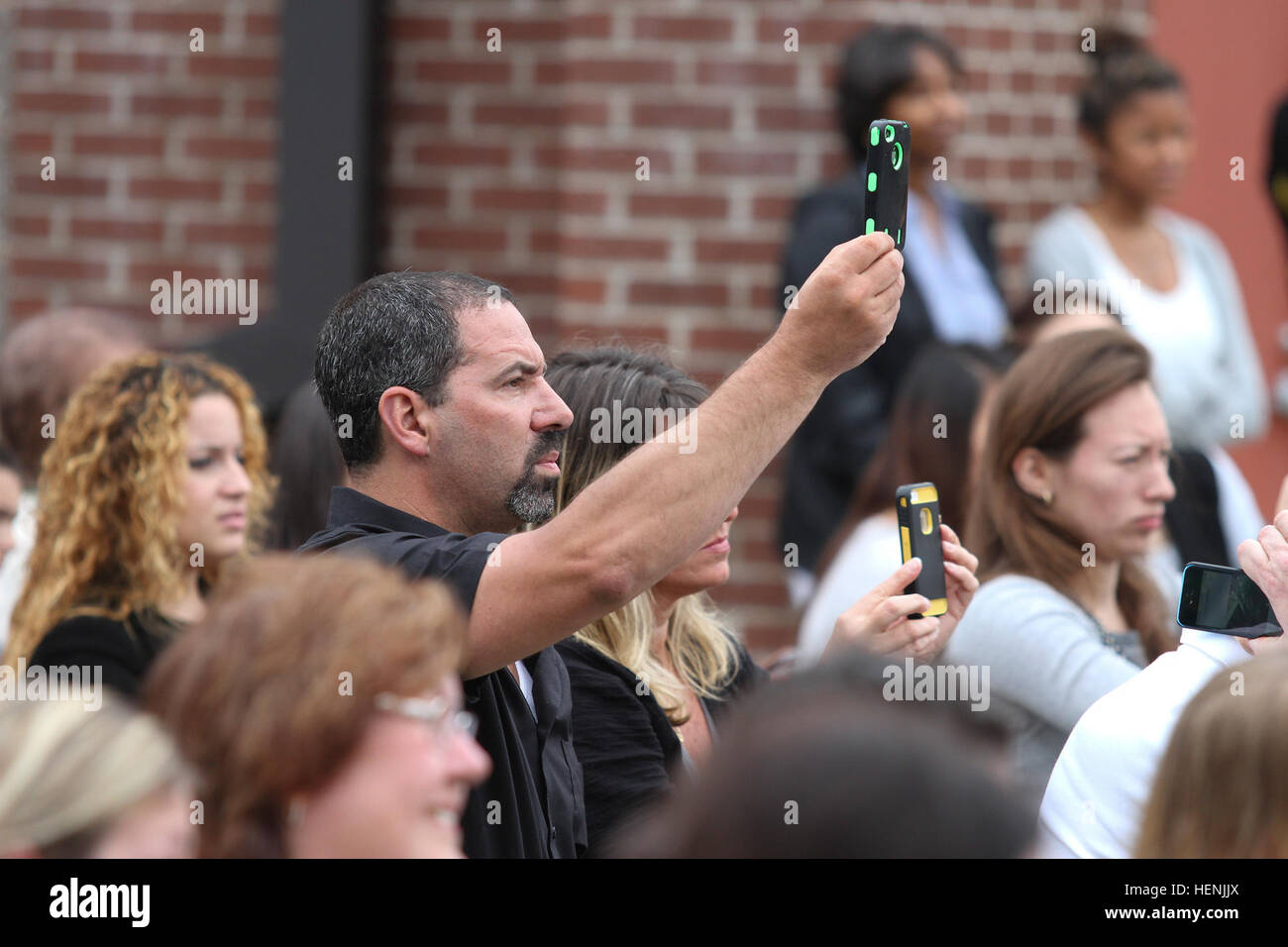 Family members take photos and videos during a departure ceremony for ...