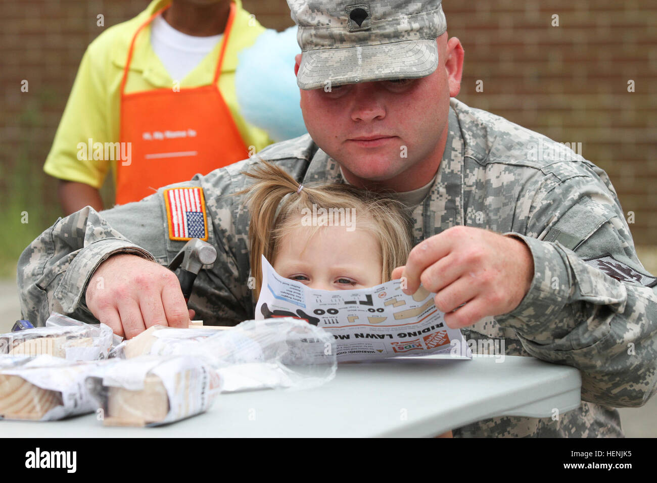 Army Reserve Spc. Cory Birk, helps his daughter, Maddyson, 2, with a ...