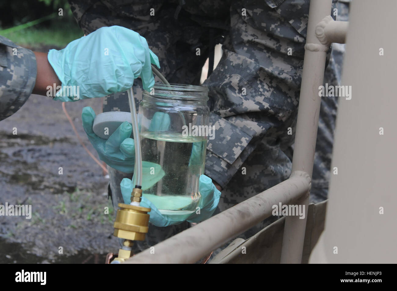 Petroleum laboratory specialists take a sample of JP-8 to analyze in ...