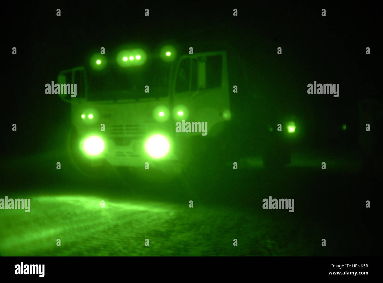 A Light Medium Tactical Vehicle waits in the dark as soldiers of ...