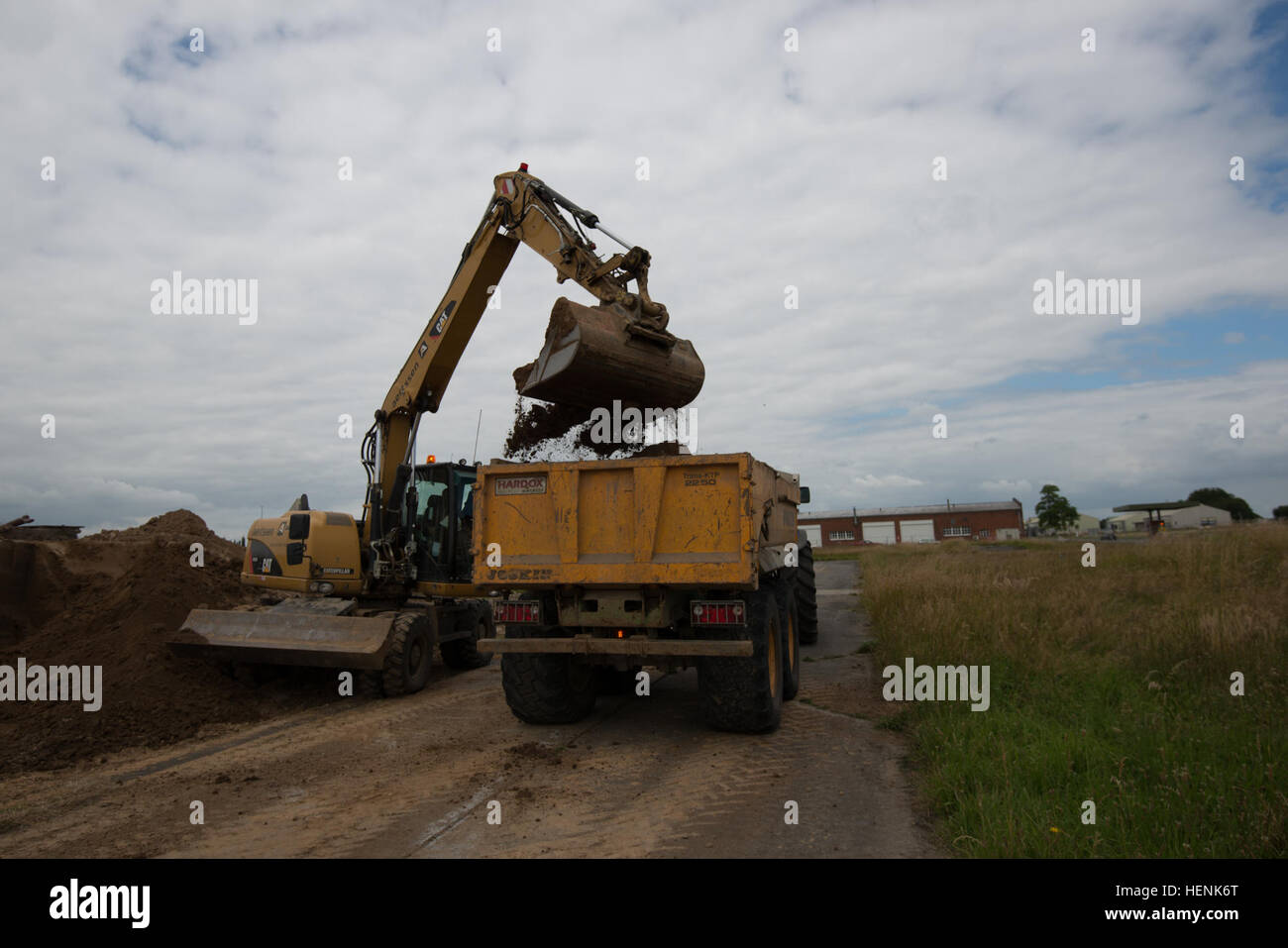 Belgian contractors operate a wheeled excavator to remove and test soil ...