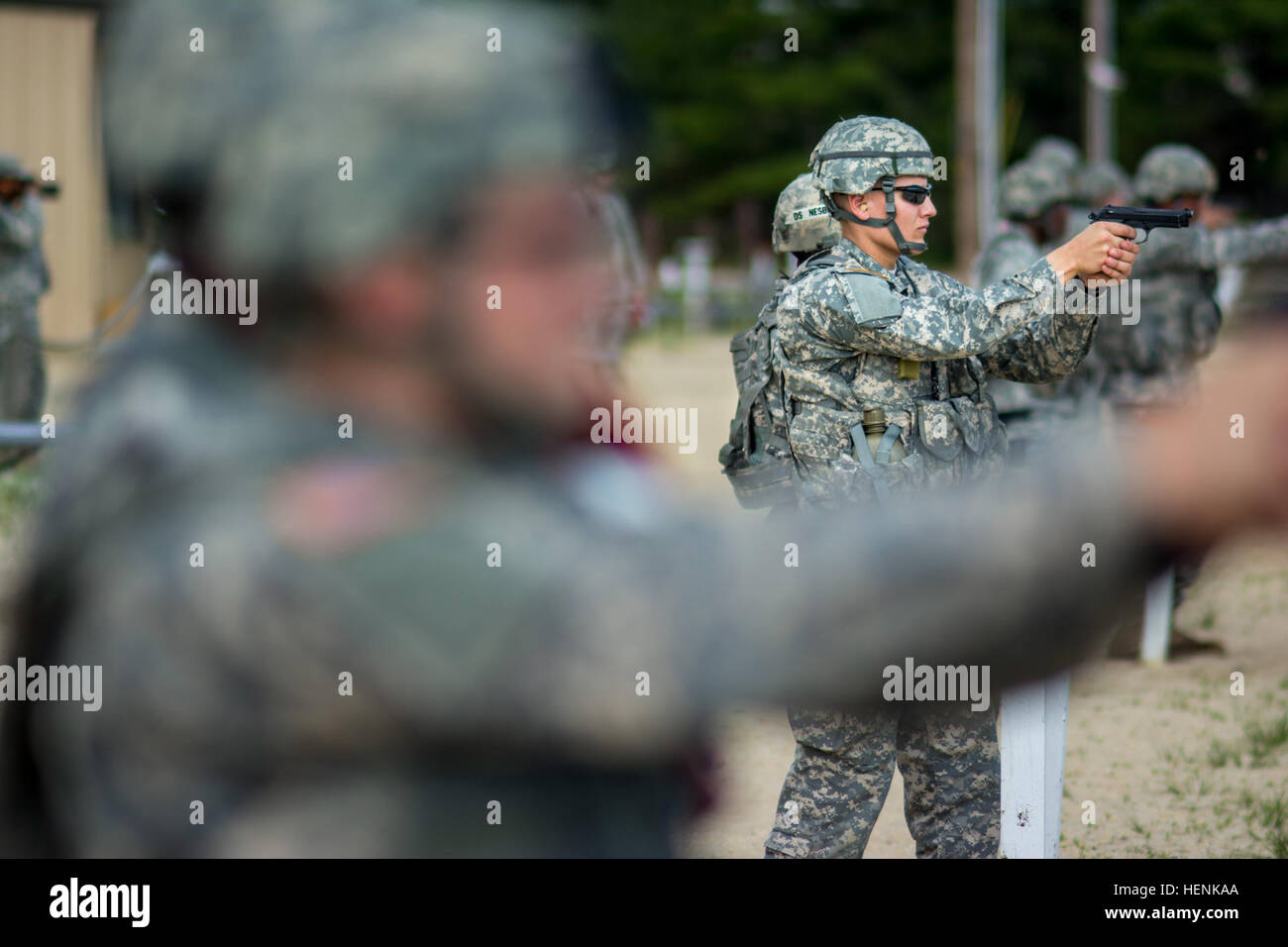 A Soldier from the 198th Army Band fires a 9mm pistol at pop-up targets ...