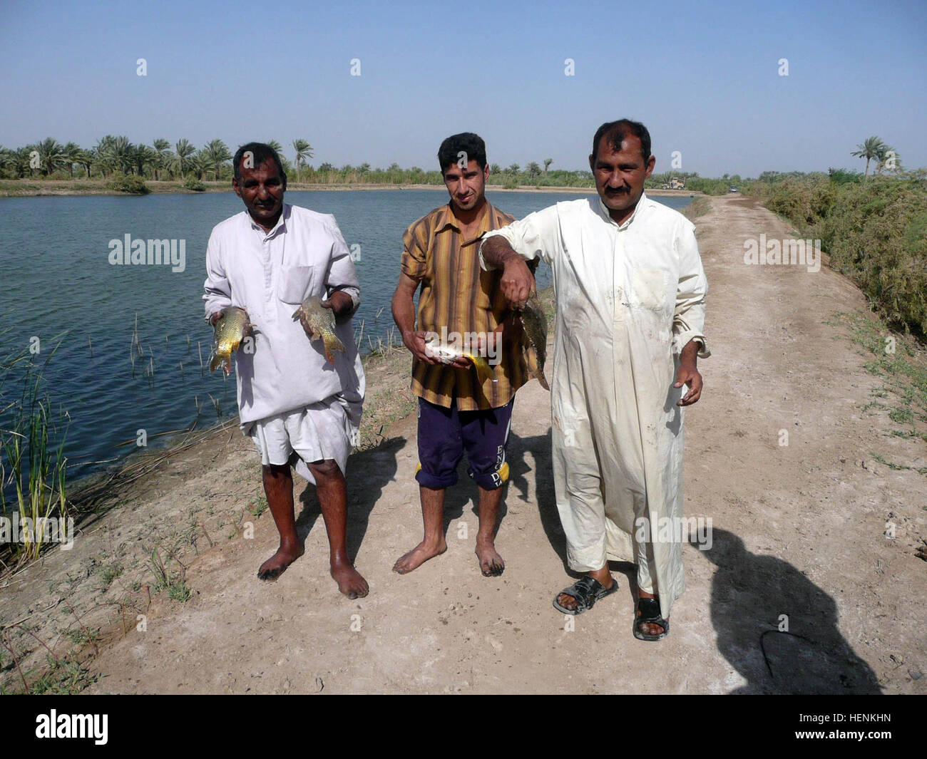 The owners of an Arab Jassim fish farm proudly display fish from their ...