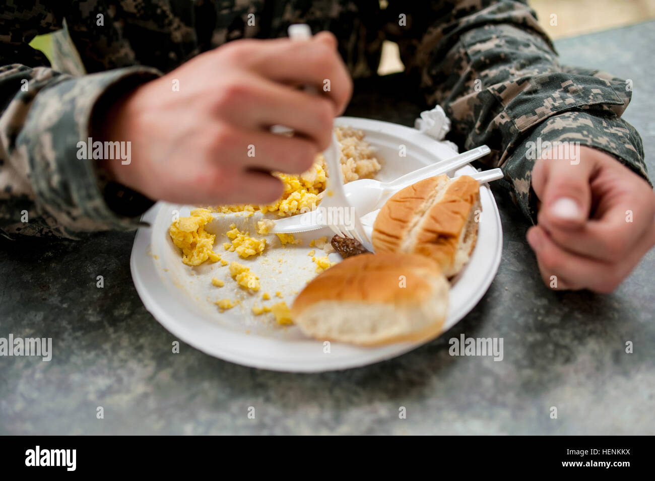A Soldier eats eggs and sausage after an 8-mile road march during the ...
