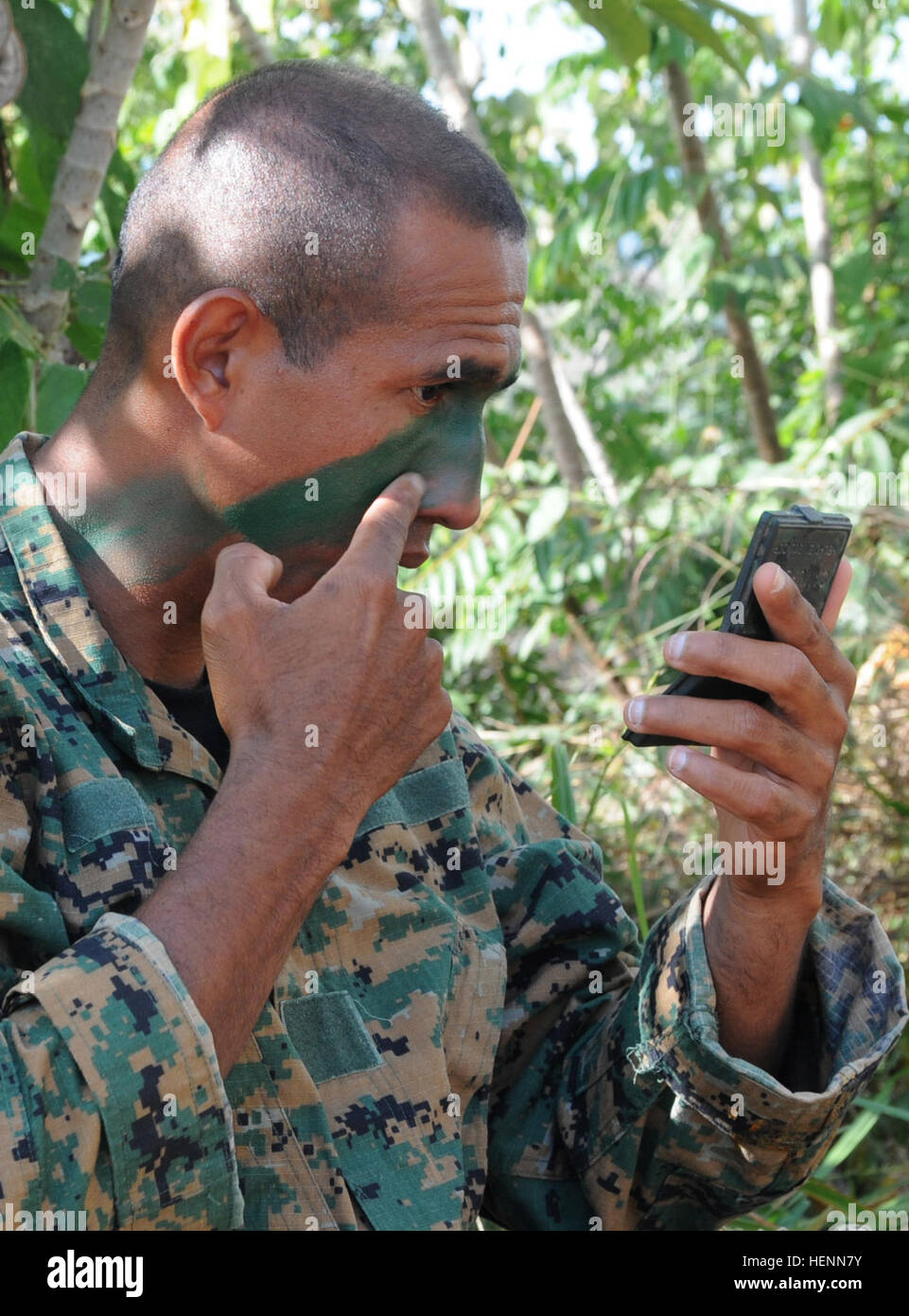 A member of the Panama sniper team applies camouflage face paint to ...