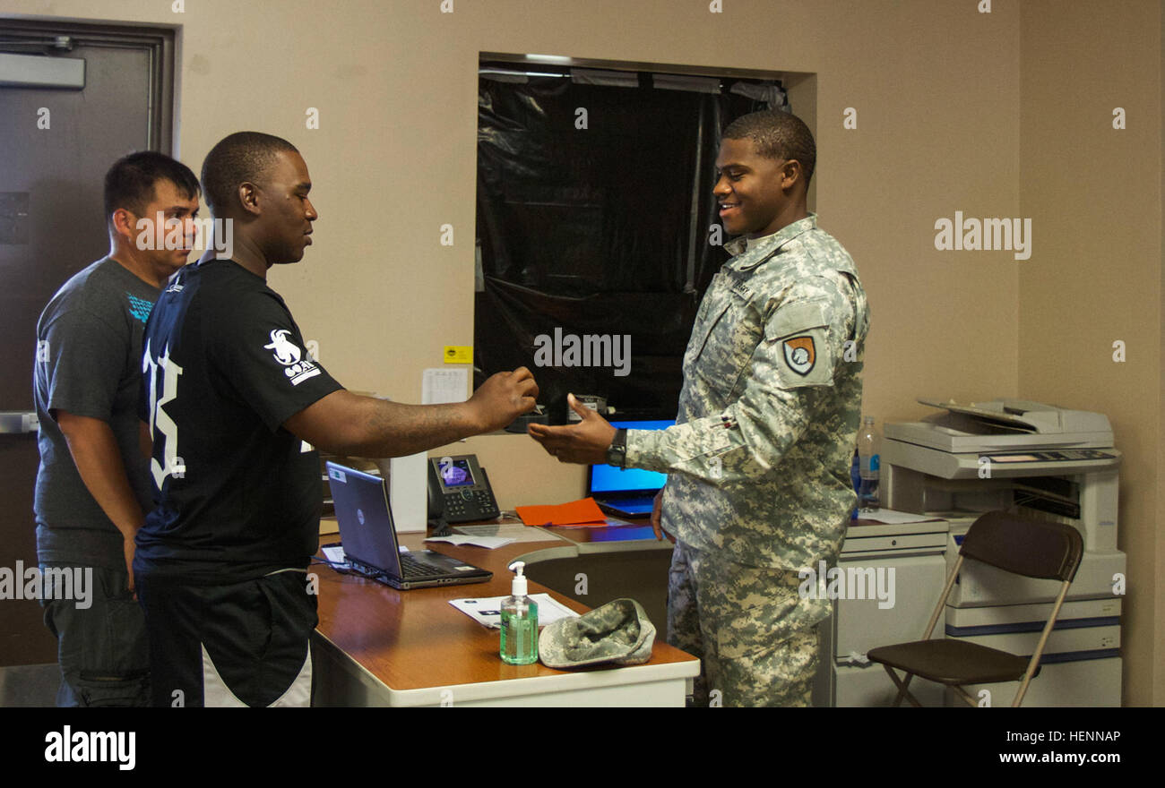 Pfc. Dwight Wells receives a military identification card from a ...