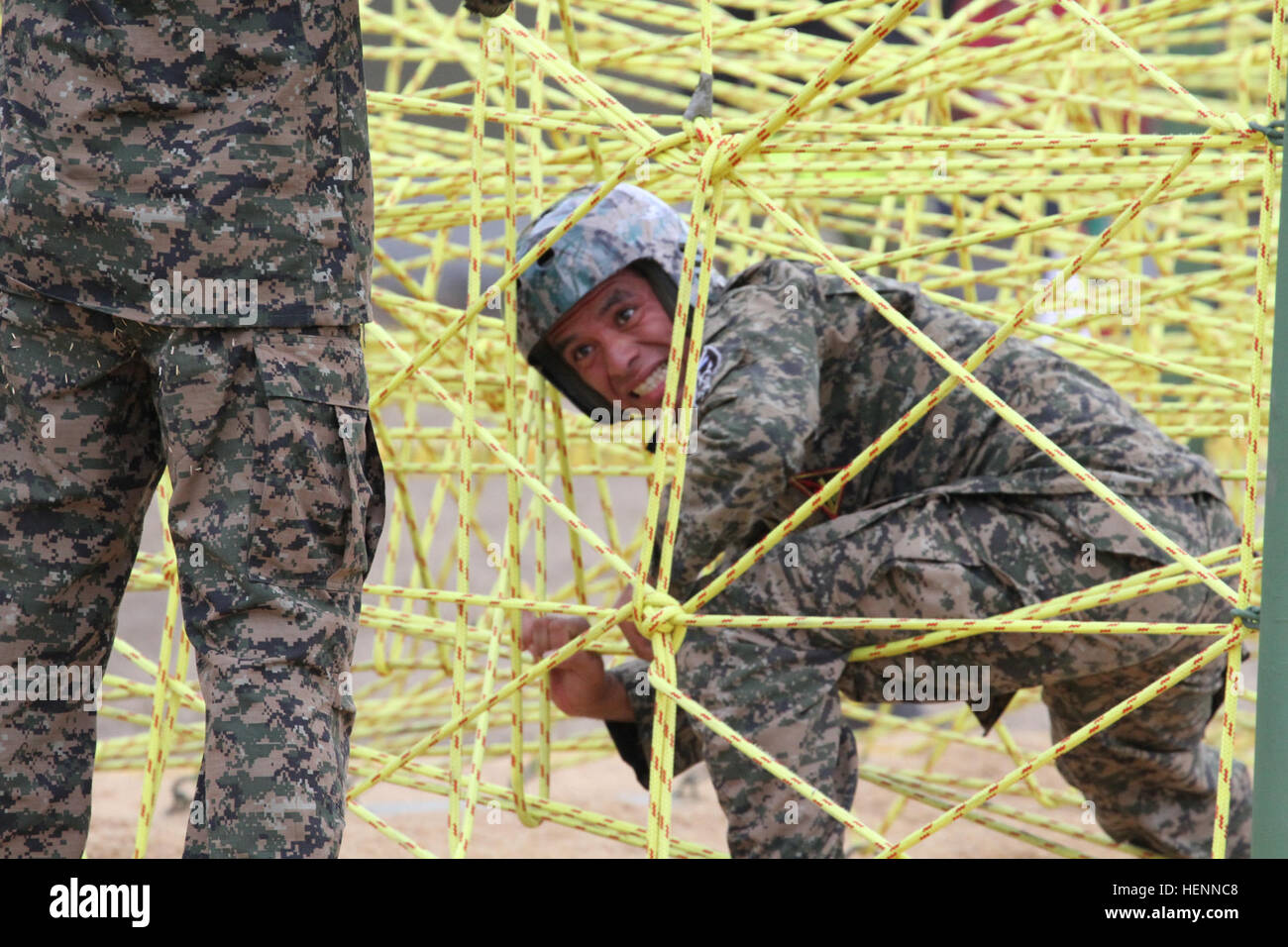 A member of El Salvador tries to get out of the spider web obstacle ...
