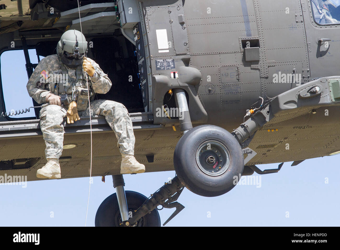 A Florida Army National Guard UH-60M crew chief uses a hoist to lift an ...