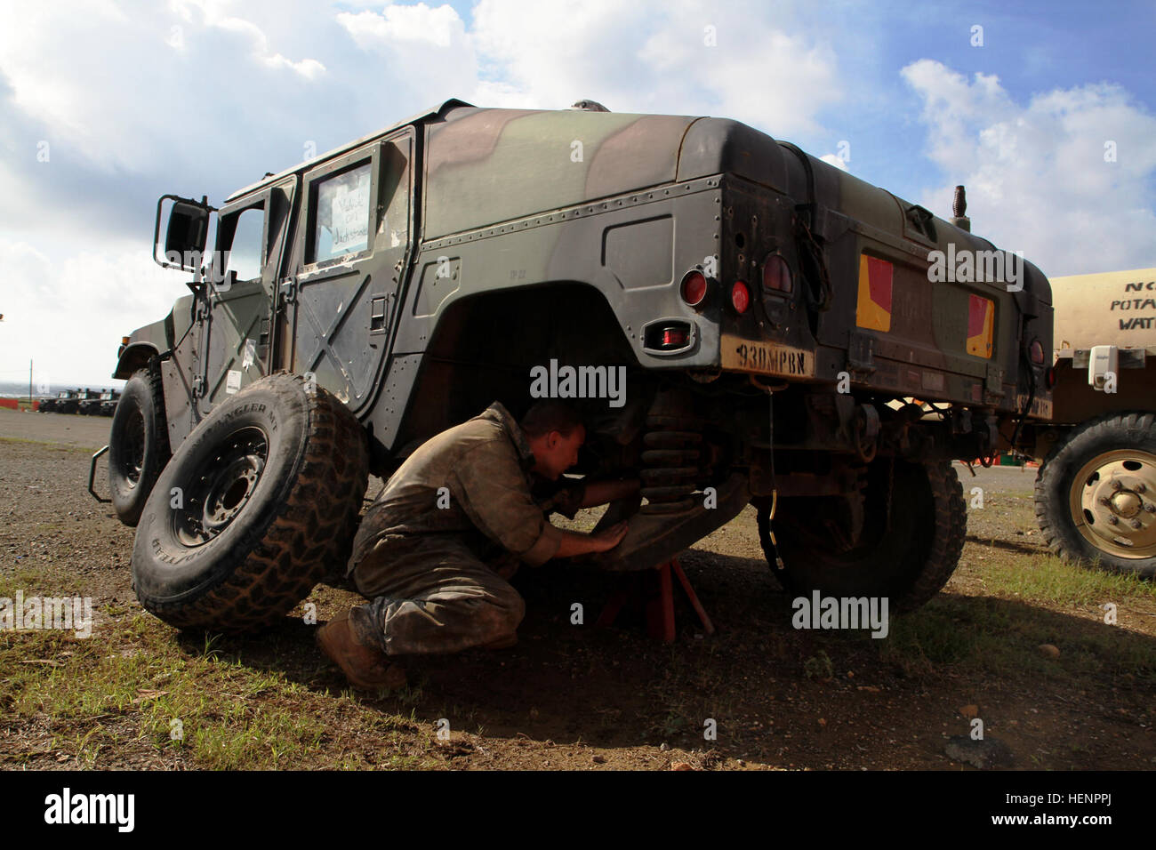 Spc. Benjamin Kelley, with the 391st MP Battalion, works underneath a ...
