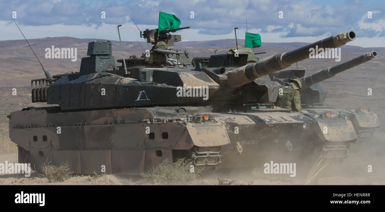 Japanese soldiers prepare a Type 10 main battle tank for a maneuver ...