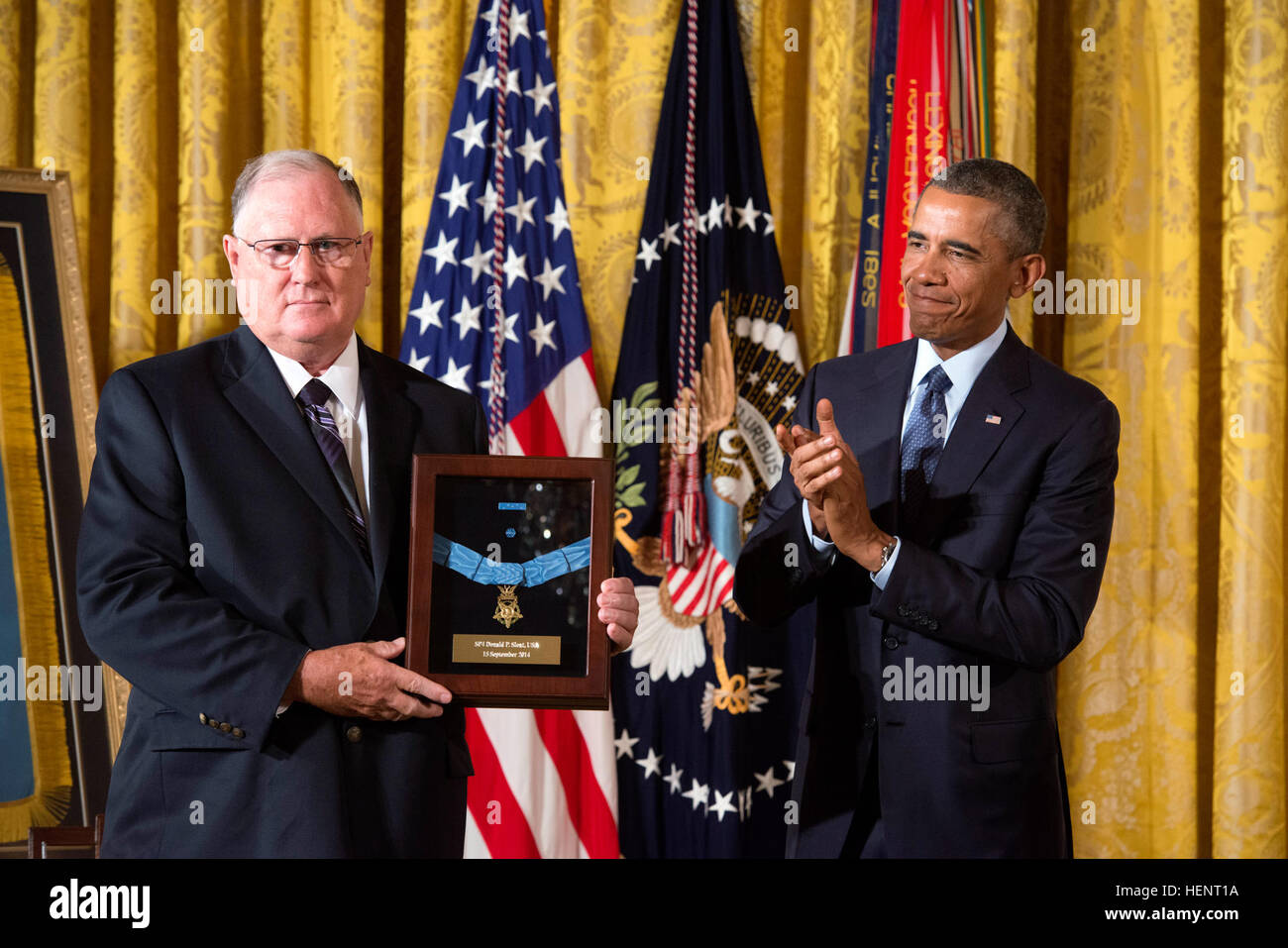 President Barack Obama applauds as Dr. William Sloat holds the Medal of ...