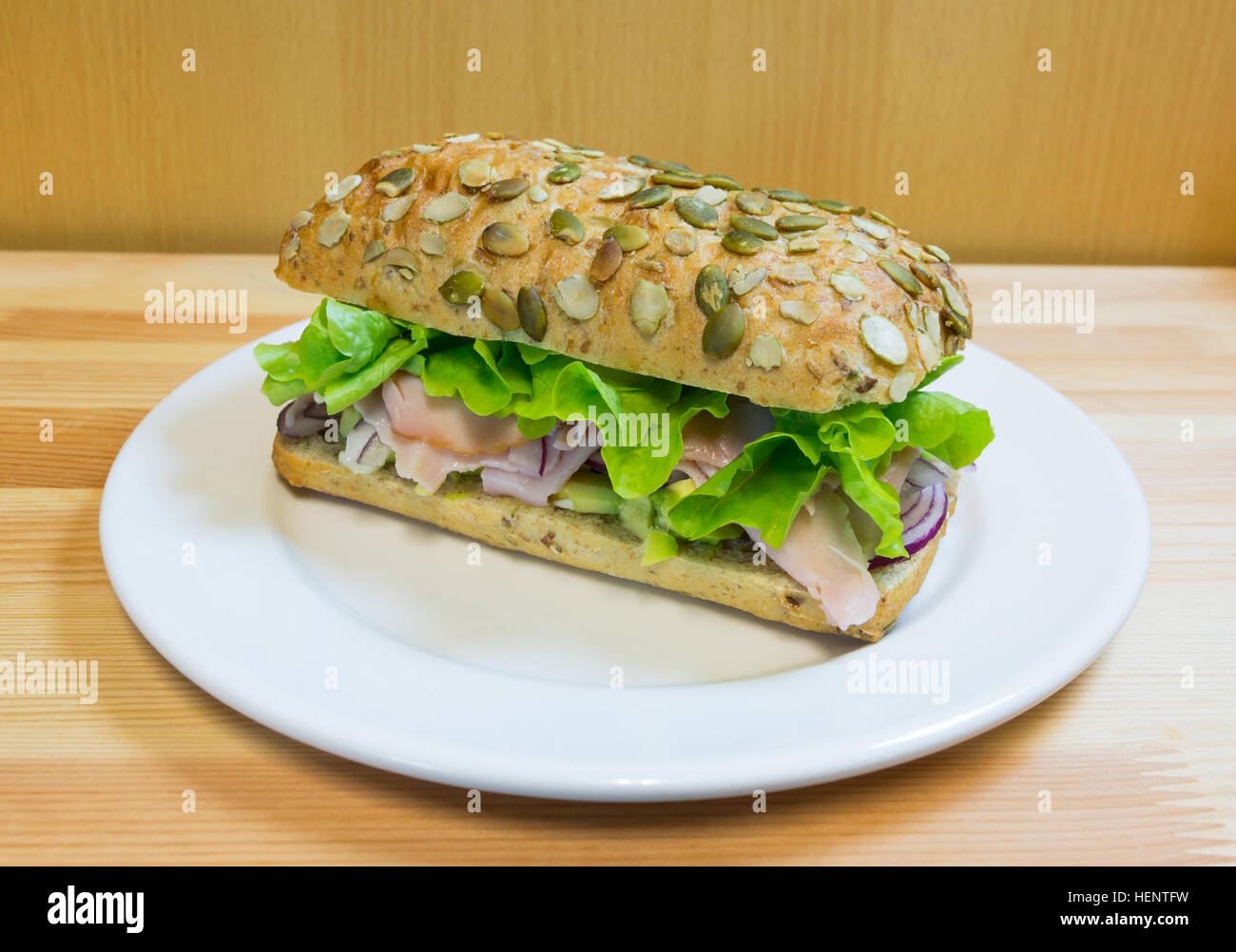 Sanwich roll with fresh vegetable and ham on a clean white plate Stock ...