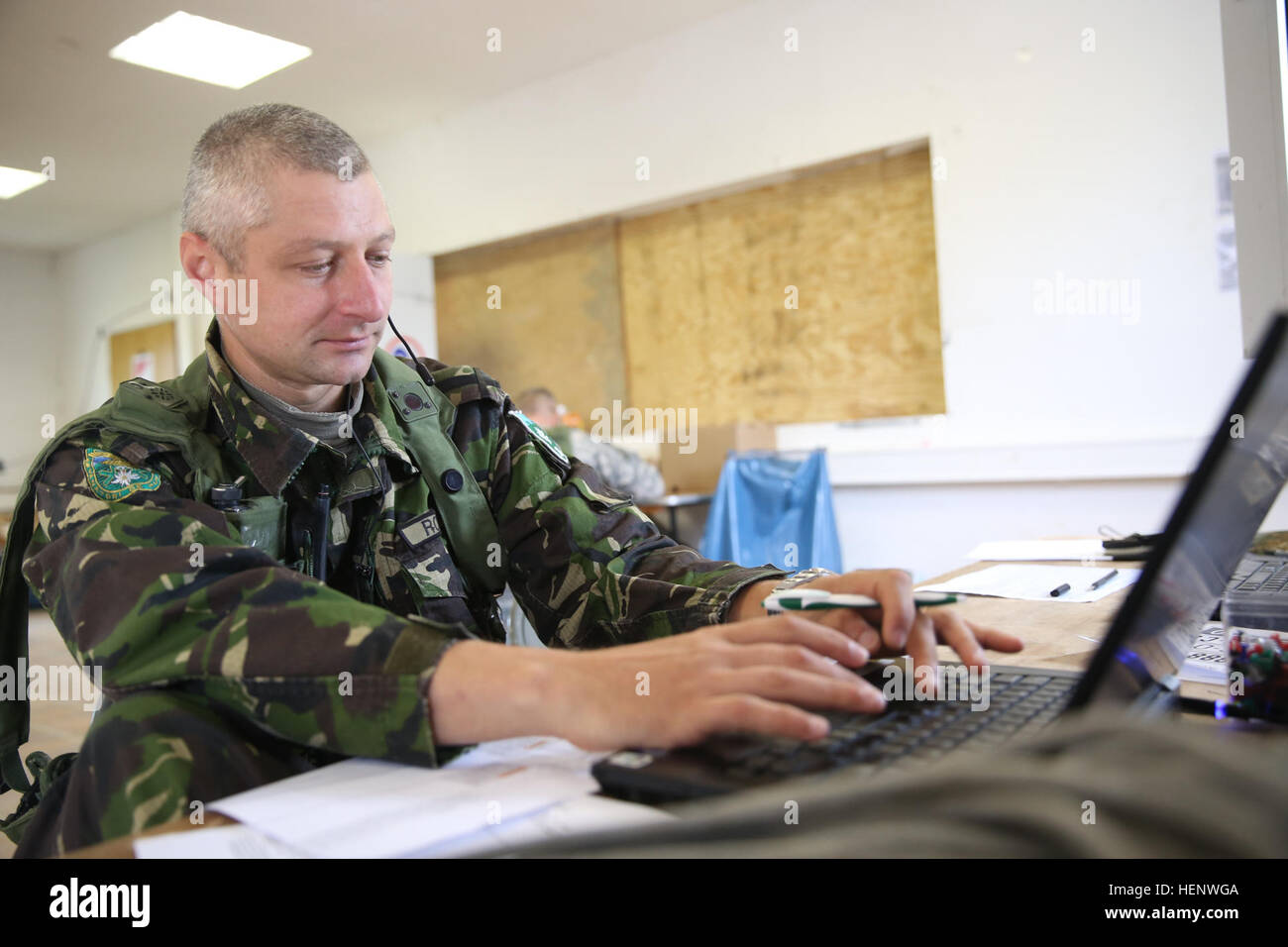 A Romanian soldier types on a computer while conducting tactical ...