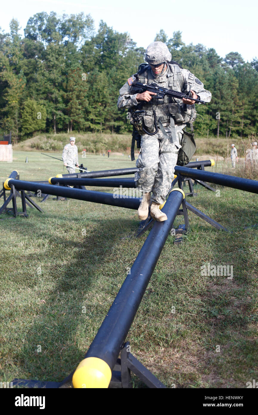 U.S. Army Staff Sgt. Victor Munoz walks across a log obstacle during ...