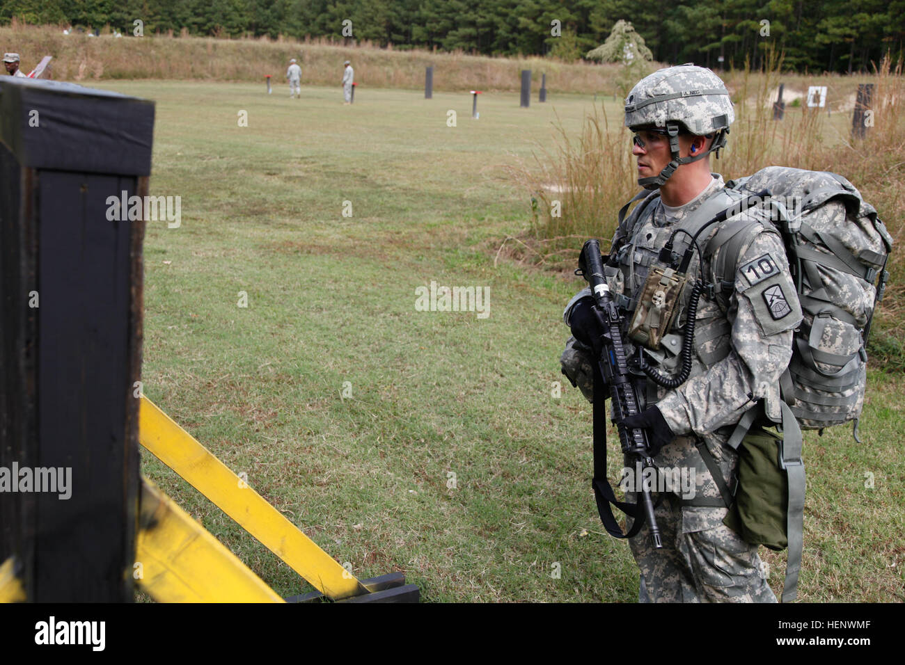 U.S. Army Spc. Cole Spoon prepares to climb over an obstacle to receive ...