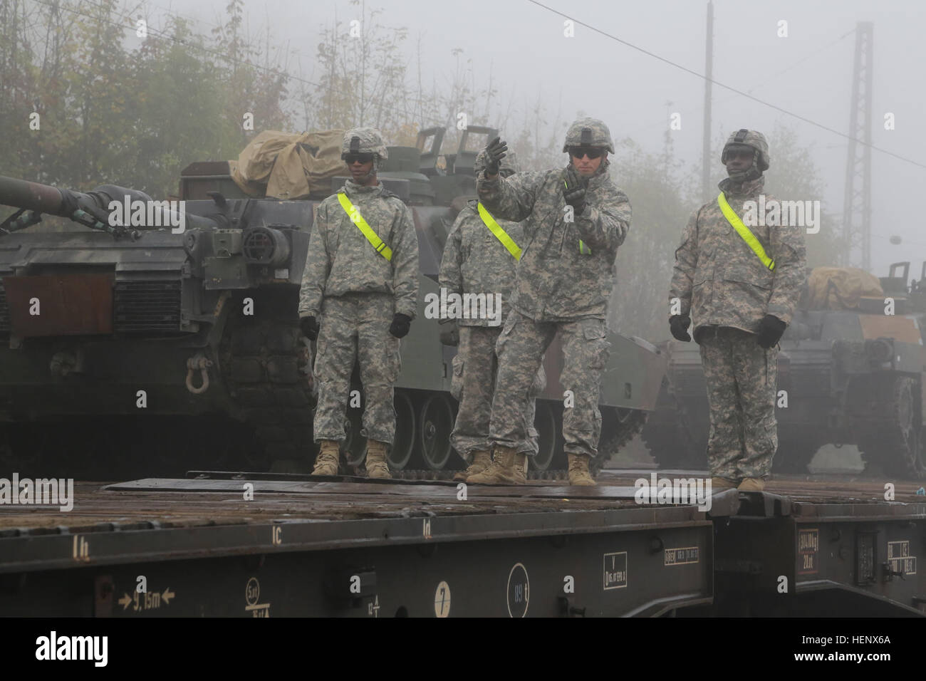 A U.S. Army officer uses hand signals to guide a tank during Combined ...