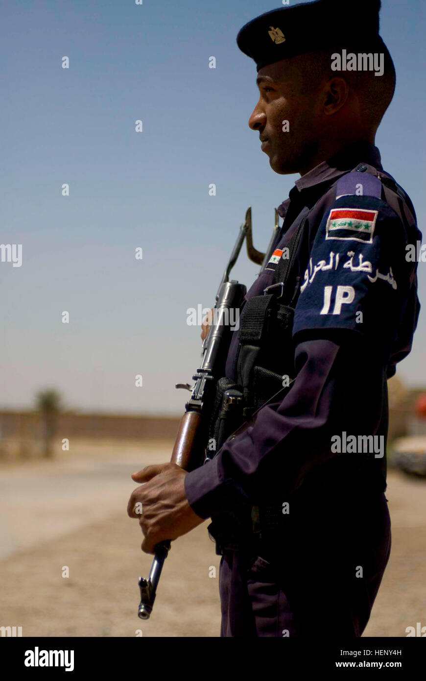 An Iraqi policeman stands guard over a graduation ceremony at the ...