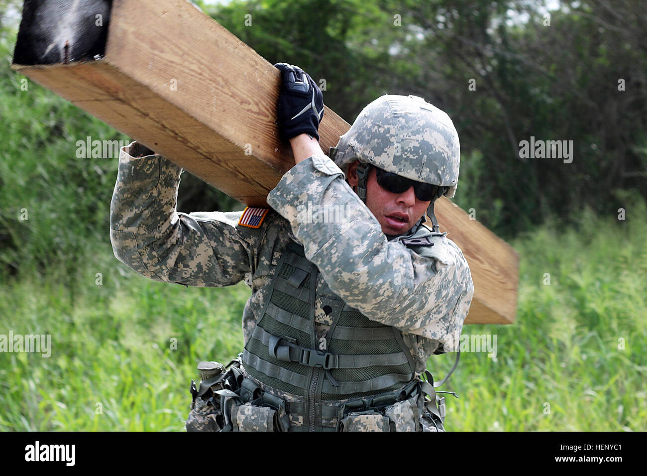 Army Spc. Jesus G. Pastrana carries a wood beam through the first ...