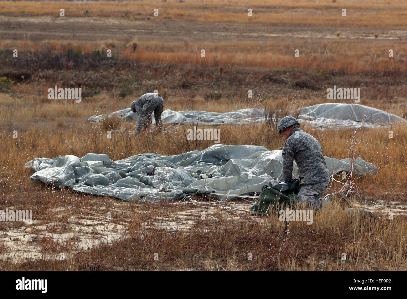 Two Soldiers start packing up their parachutes after landing on Sicily ...