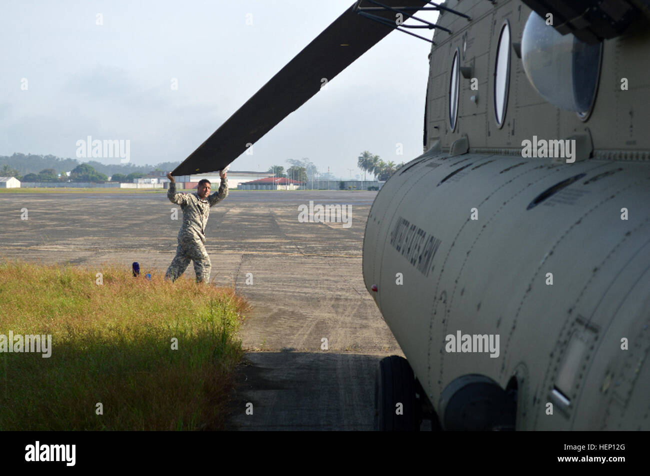 A CH-47 Chinook helicopter is preflight checked by a crew chief from ...