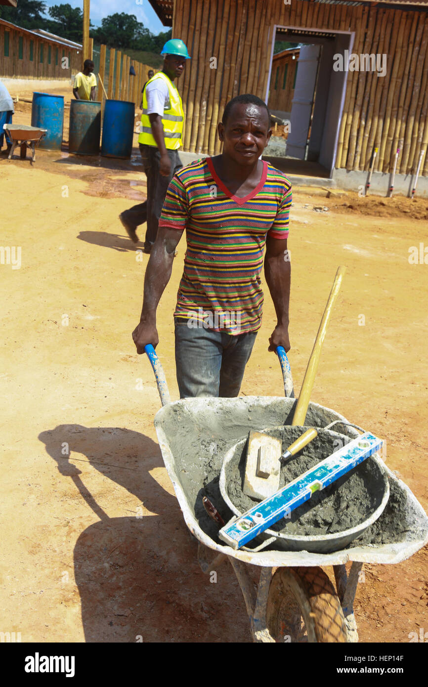 A local Liberian worker hauls cement at the construction site of a new ...